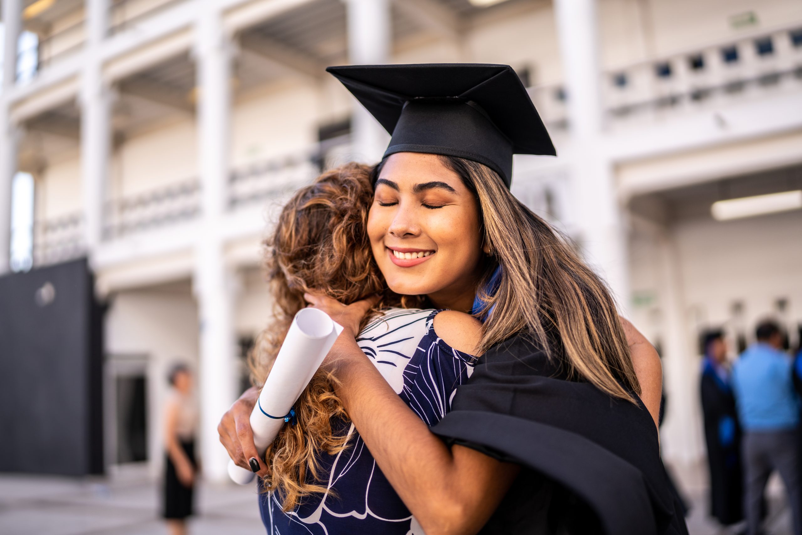 Young graduate woman embracing her mother on graduation - Risk ...