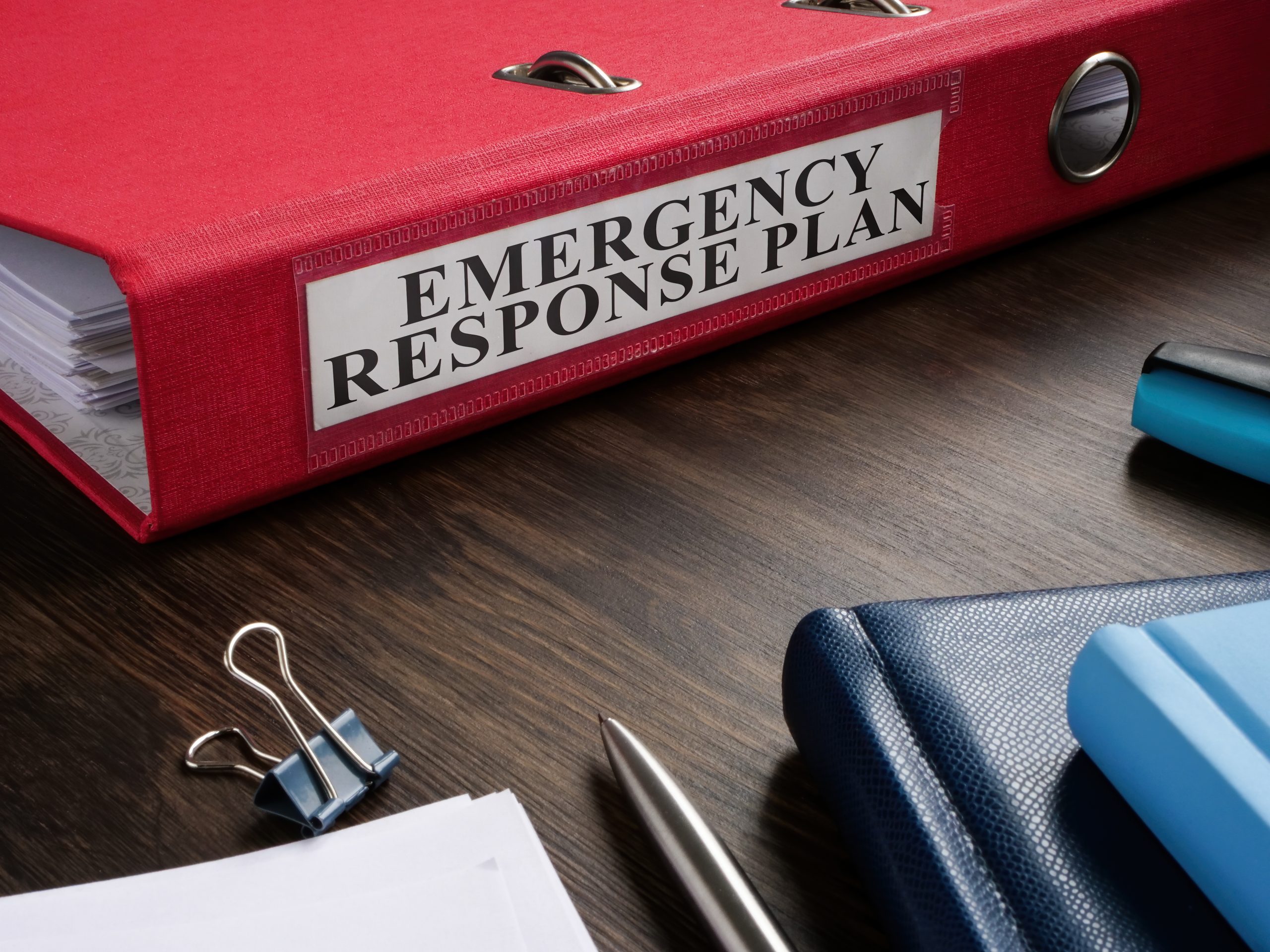 Red folder with Emergency response plan on the desk. - Risk & Insurance ...